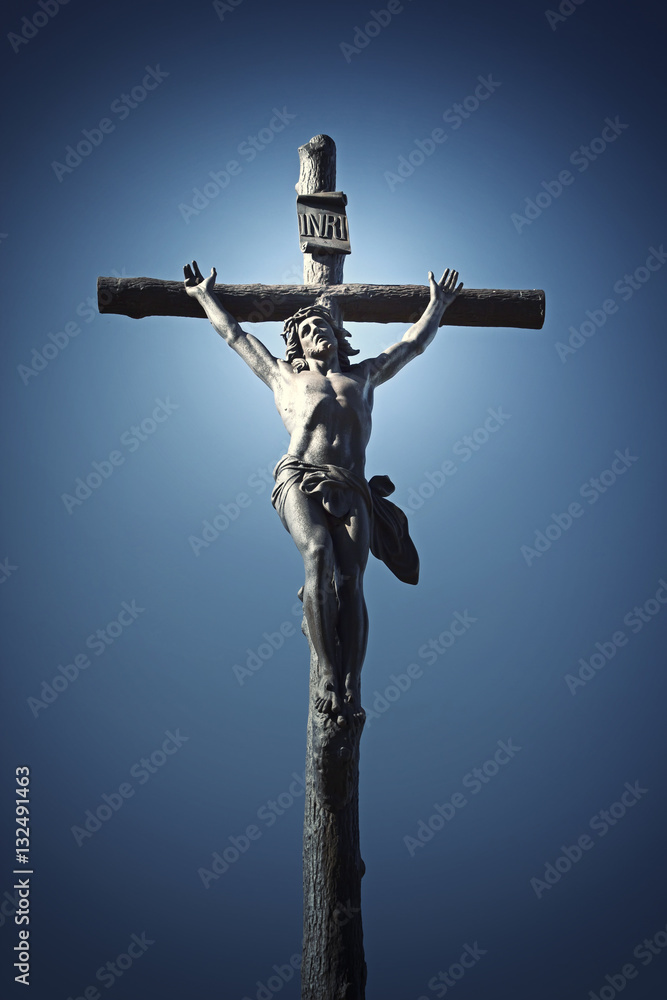 Statue of Jesus Christ on a cross. Blue sky in the background ...