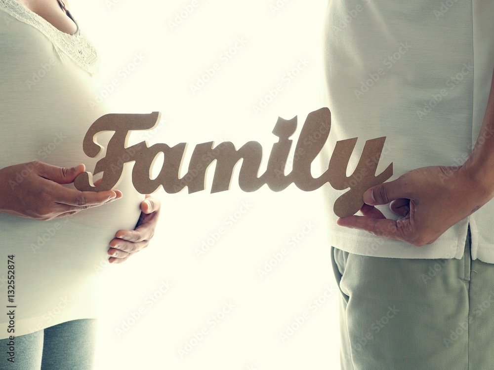 Pregnant woman with husband holding family message for incoming baby ...