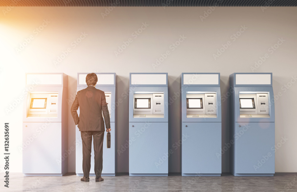 Rear view of a man near five ATM machines Stock-Foto | Adobe Stock