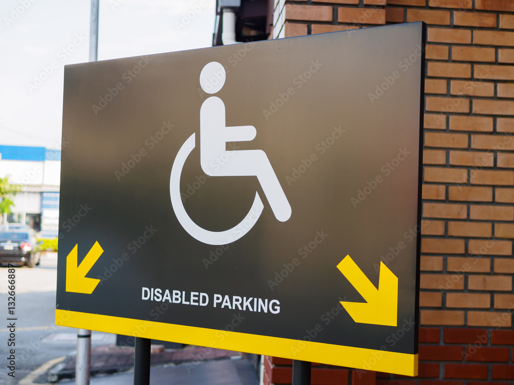 Disabled parking space sign and symbols on a pole warning motorists ...