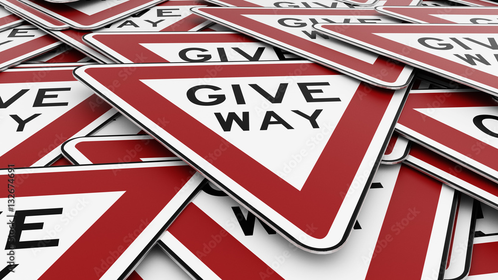 Ordered pile of red, black, and white give way traffic signs. This imge ...