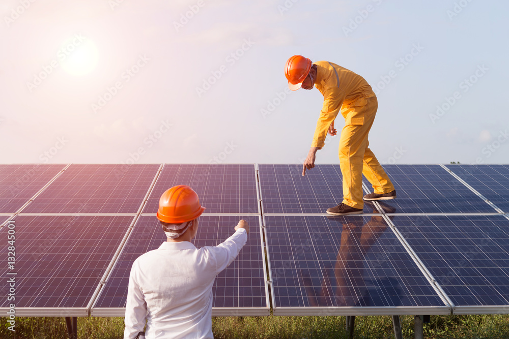 Under the sun, there are two engineers checking solar cells..Solar ...
