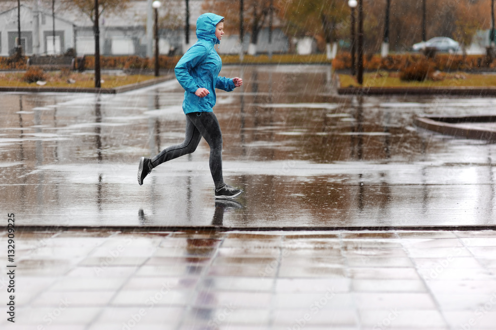 Runner woman running in Park in the rain. Jogging training for m Stock ...