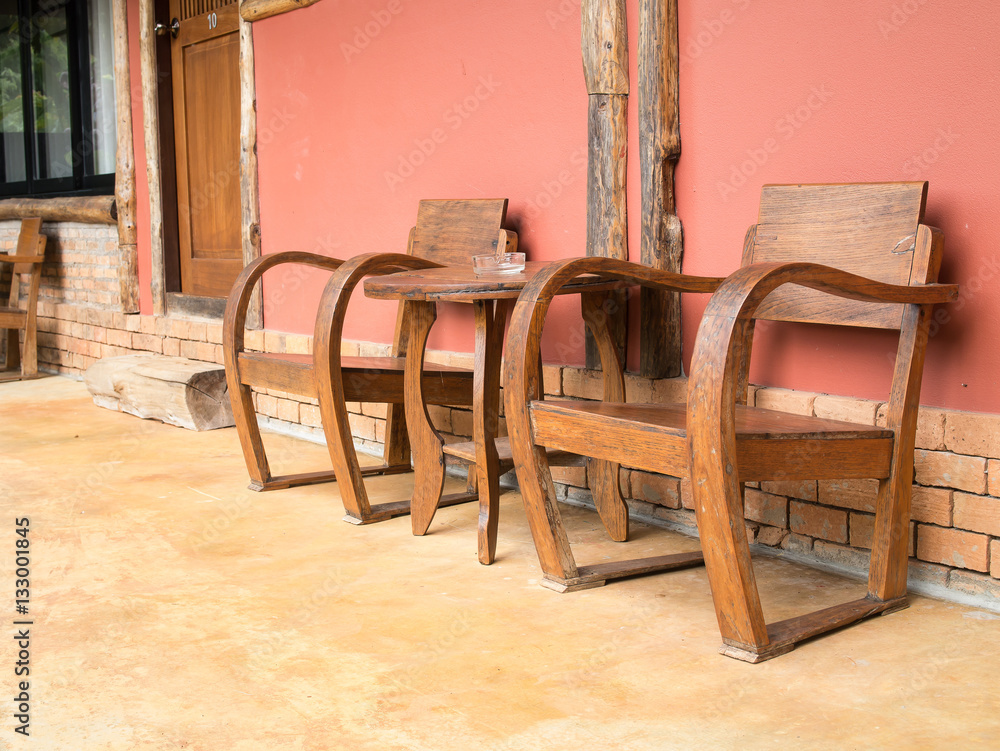 Wood table and chair in front of a wall Stock Photo | Adobe Stock