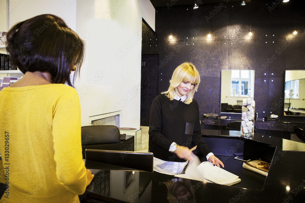 Customer and receptionist in hair salon Stock Photo | Adobe Stock