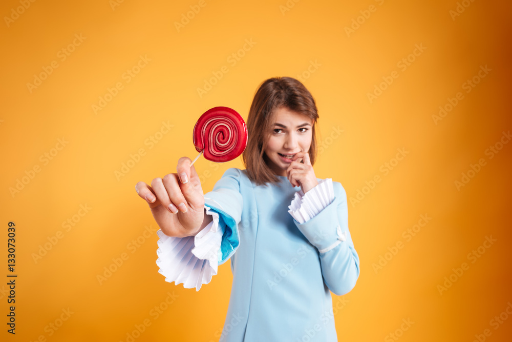 Pretty cute young woman giving you red lollipop Stock Photo | Adobe Stock