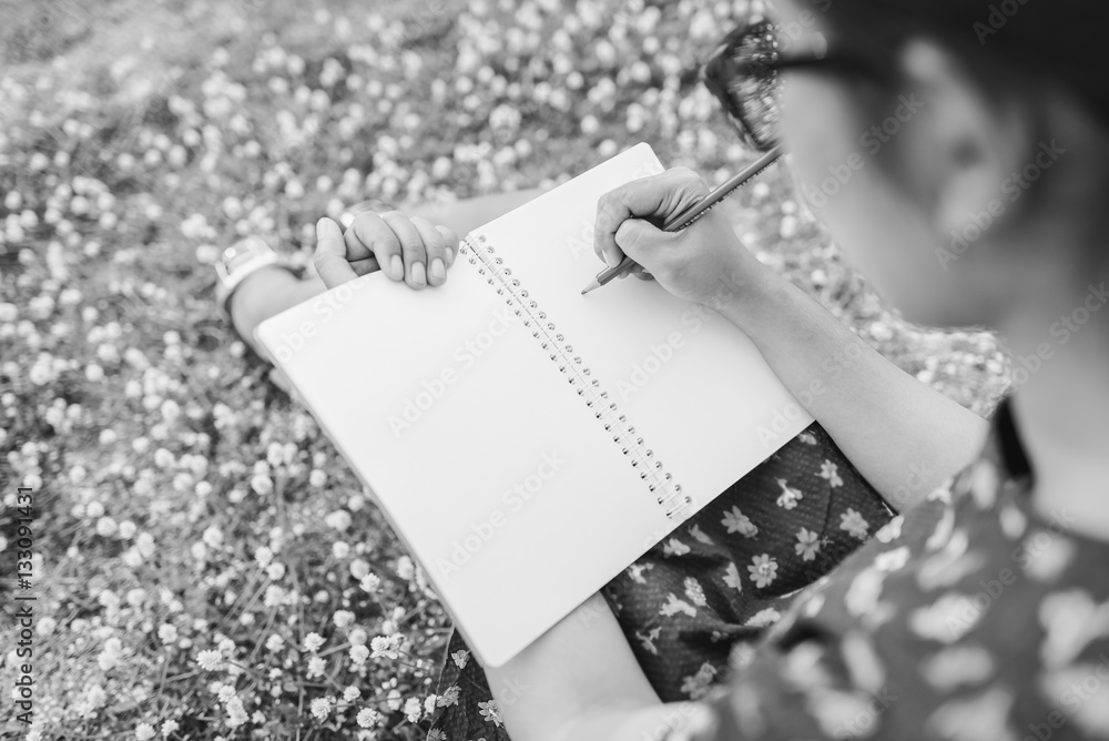 woman writing in her diary on the meadow with white flowers Stock Photo ...