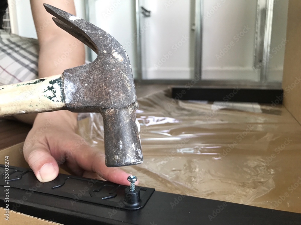 worker use hammer to build wooden table Stock Photo | Adobe Stock