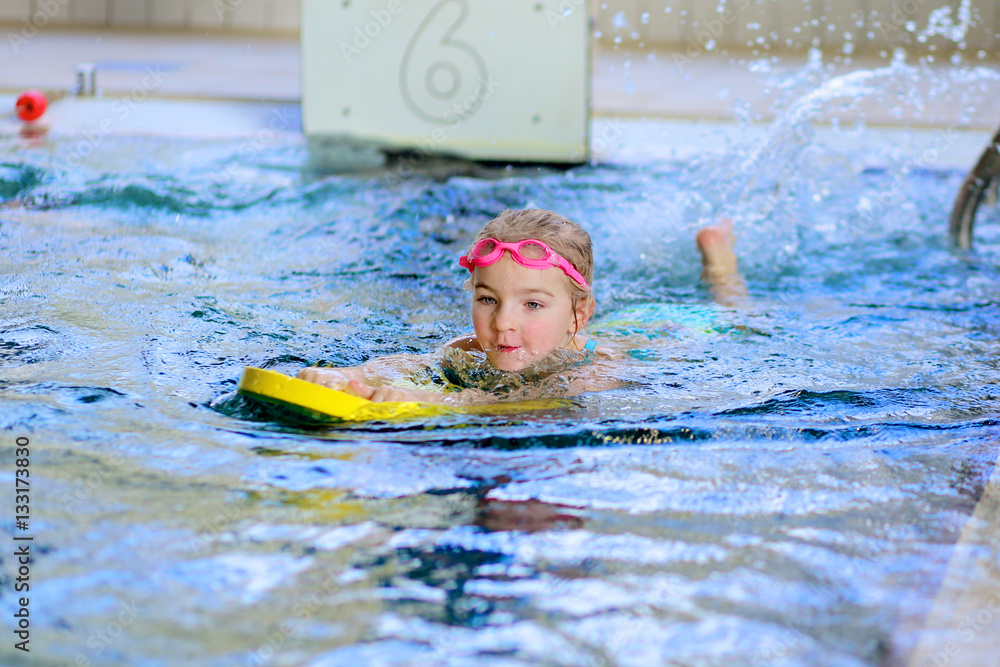 Little girl learning to swim in big sport pool. Swimming school for ...
