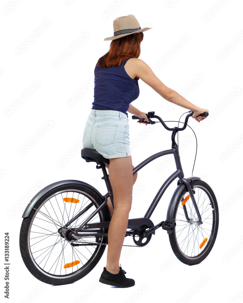 back view of a woman with a bicycle. cyclist sits on the bike. Rear ...