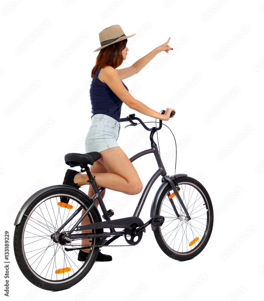 back view of pointing woman with a bicycle. cyclist sits on the bike ...