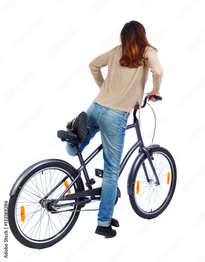 back view of a woman with a bicycle. cyclist sits on the bike. Rear ...
