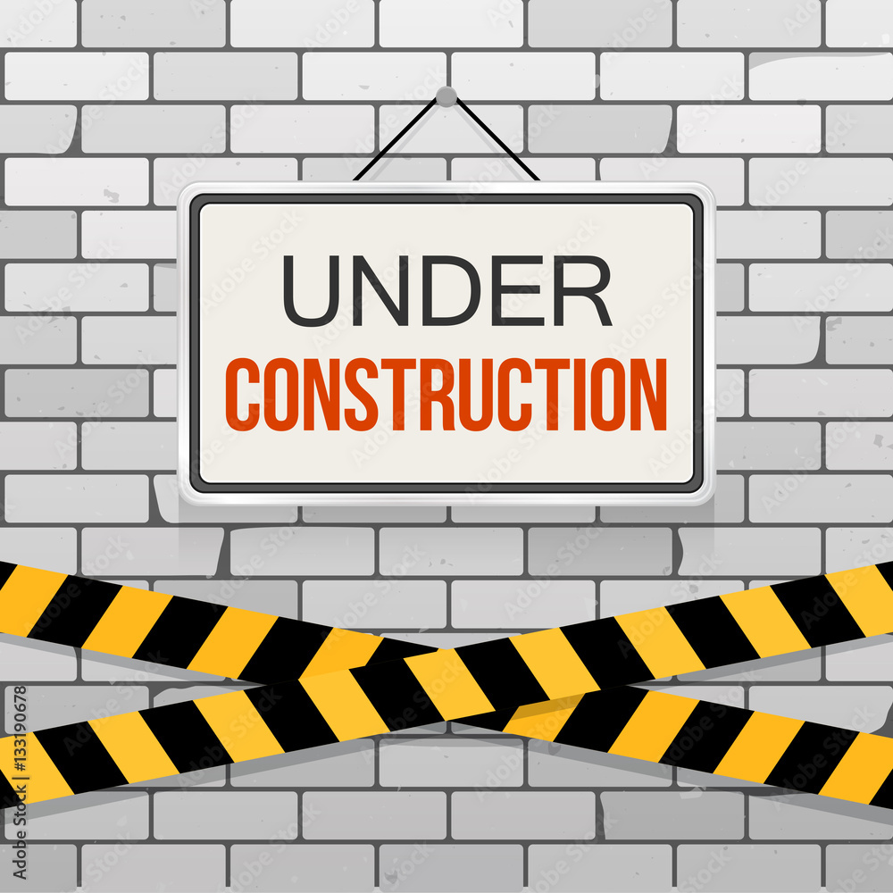 Simple white sign with text 'Under Construction' hanging on a gray ...