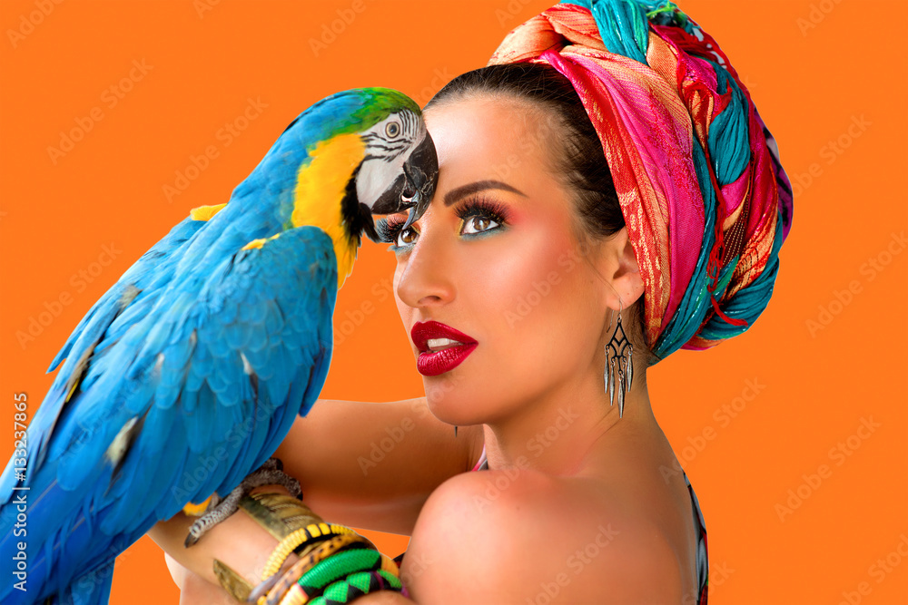 Portrait of young attractive woman in african style with ara parrot on ...