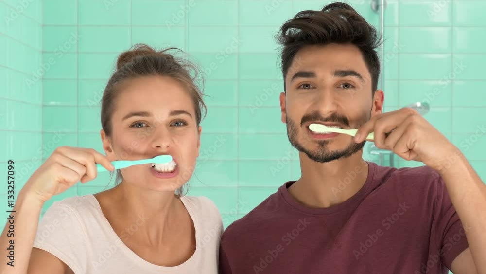 Young and healthy couple brushing teeth in bathroom having fun portrait ...