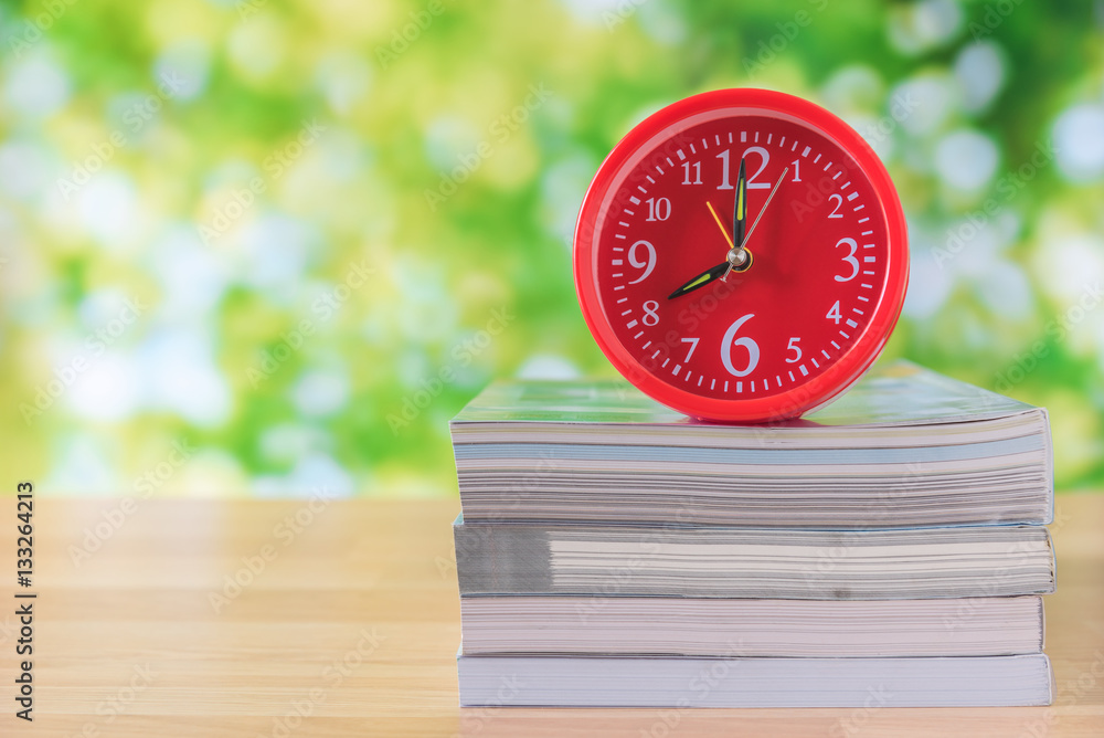 red heart clock and open book on wooden table Stock Photo | Adobe Stock