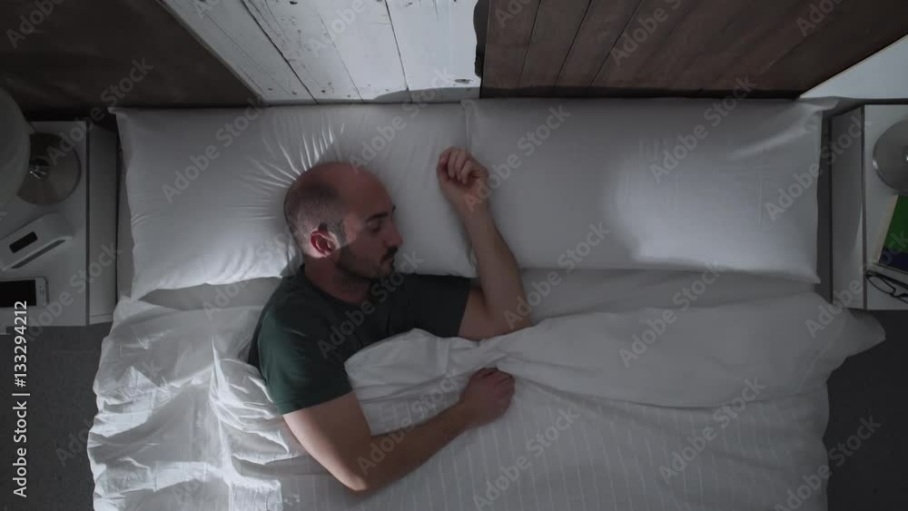 Young man sleeping deeply in her bed at night. High angle view. Stock ...
