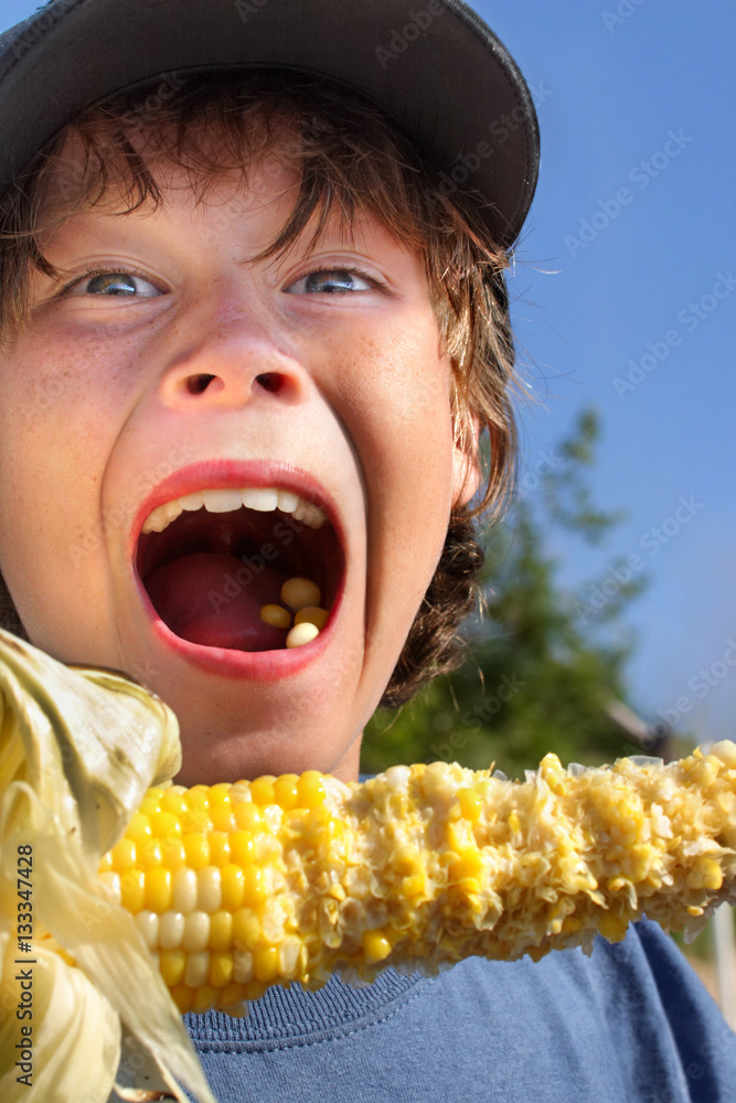 Happy boy eating corn on the cob Stock Photo | Adobe Stock