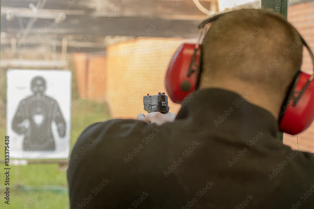 Shooting with a pistol. Man Firing pistol in shooting range. Stock ...