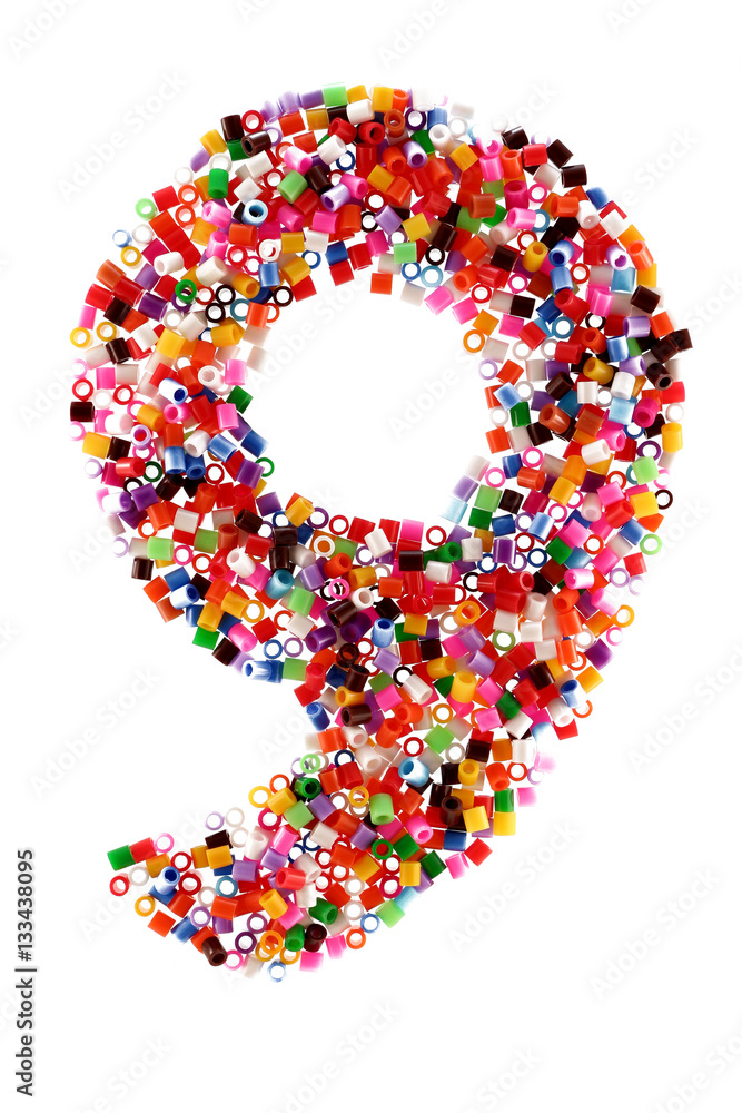 Figure nine "9" made up by plastic particles of different colors ...