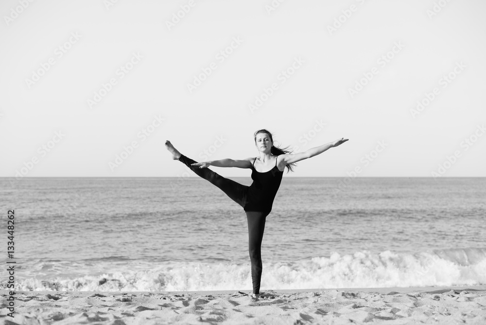 Flexible acrobatic woman in perfect shape doing exercises on sandy ...