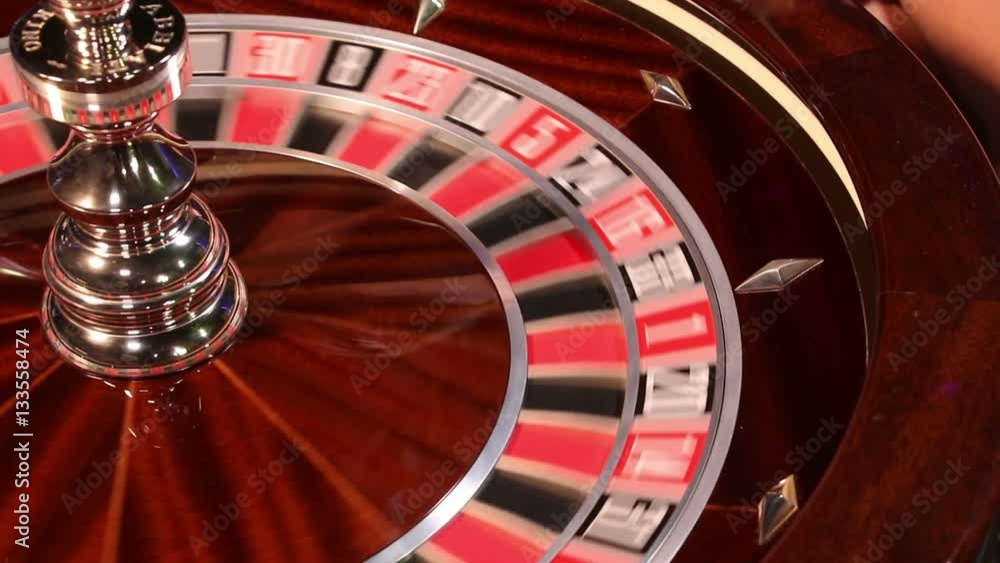 Casino roulette in motion, the spinning wheel ball and croupier hand ...