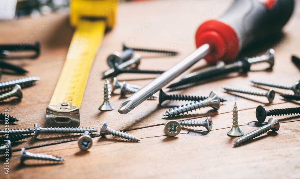 Screwdriver and nails on wooden background Stock Photo | Adobe Stock