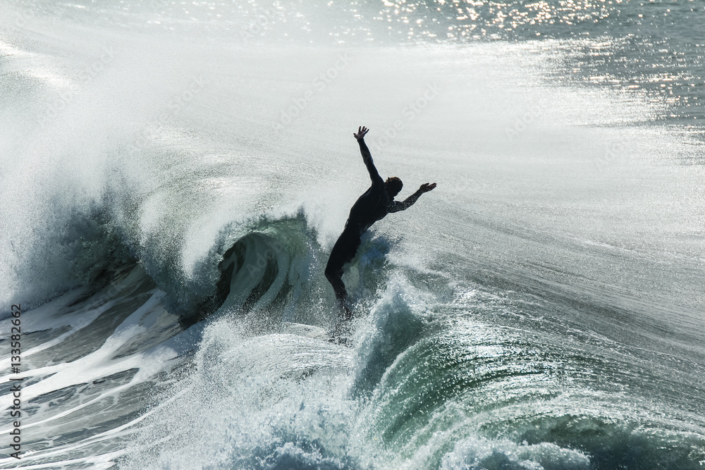 Surfer flails in the air after falling off his board on a wave Stock ...