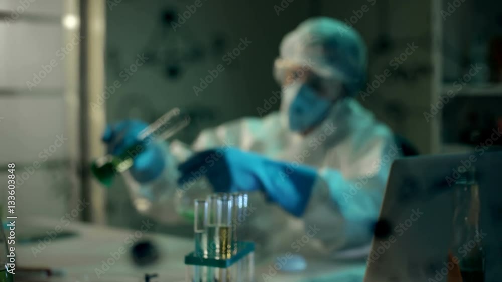 Crazy mad scientist in respirator drinks poisonous toxic liquid ...