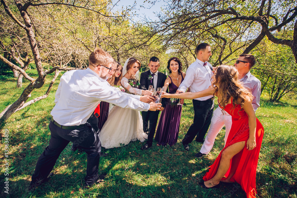 bride and groom with happy groomsmen and bridesmaids having fun and ...