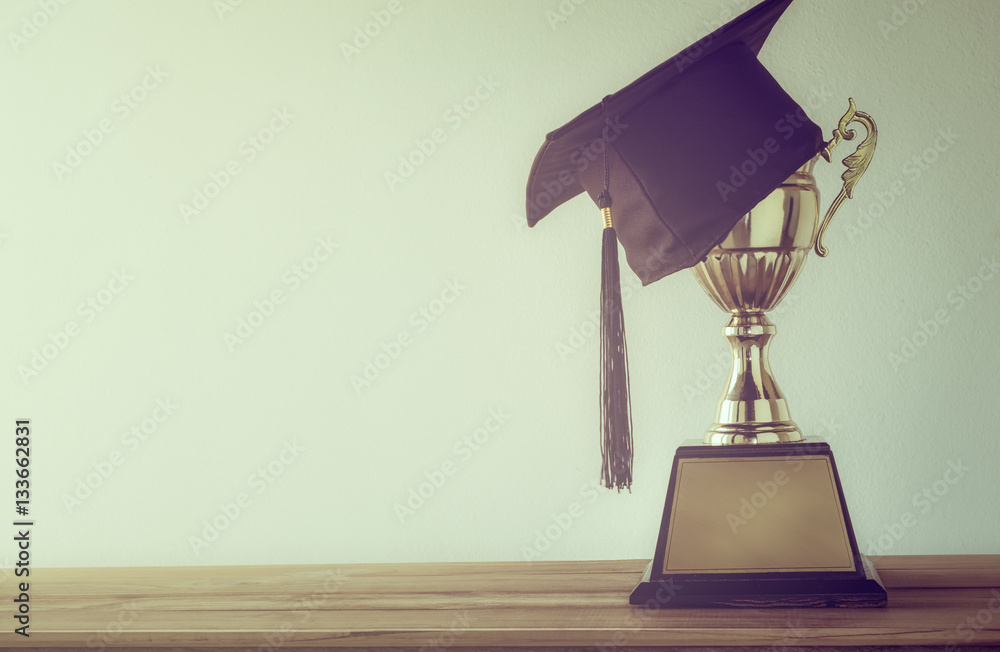 graduation cap with champion golden trophy on wood table with co Stock ...