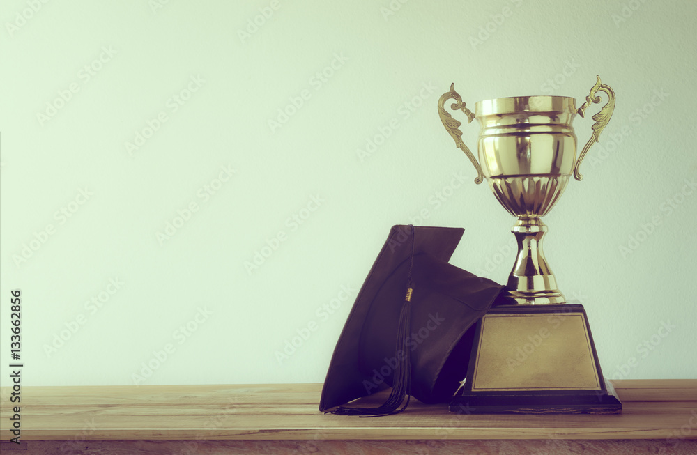 graduation cap with champion golden trophy on wood table with co Stock ...