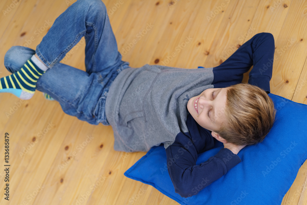 entspanntes kind liegt auf einem holzfußboden Stock-Foto | Adobe Stock