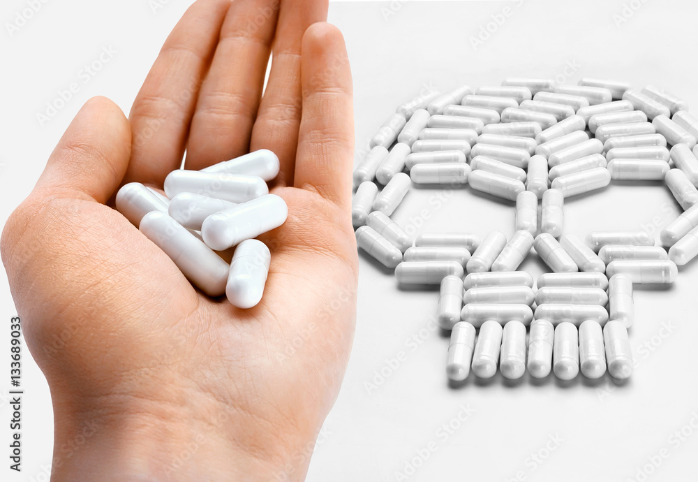 Stop Drugs! Hand with white capsules next to the skull symbol of ...