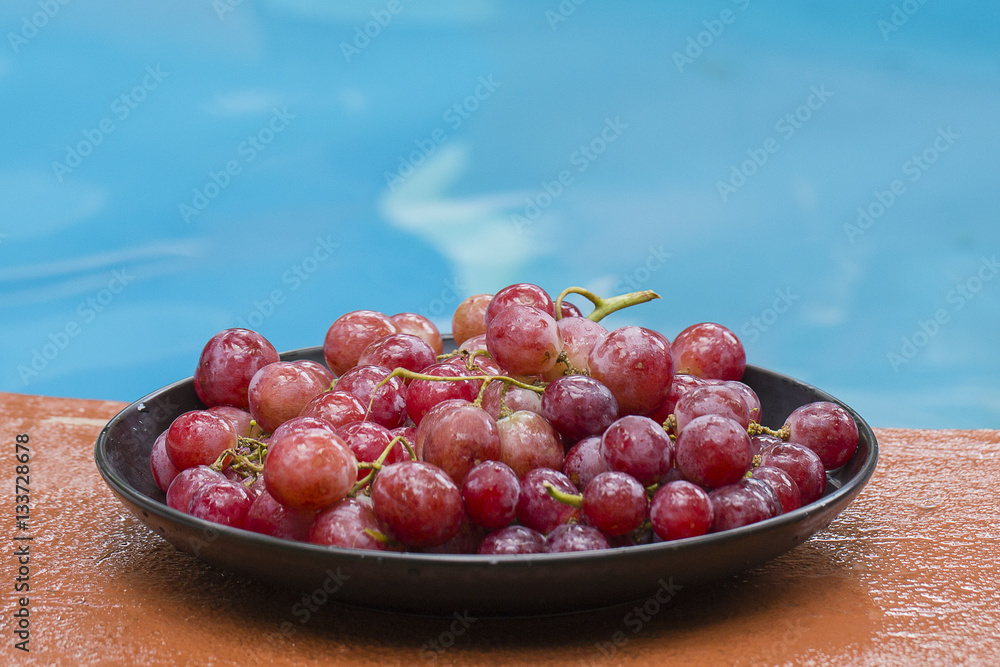 Ripe red grape near swimming pool Stock Photo | Adobe Stock