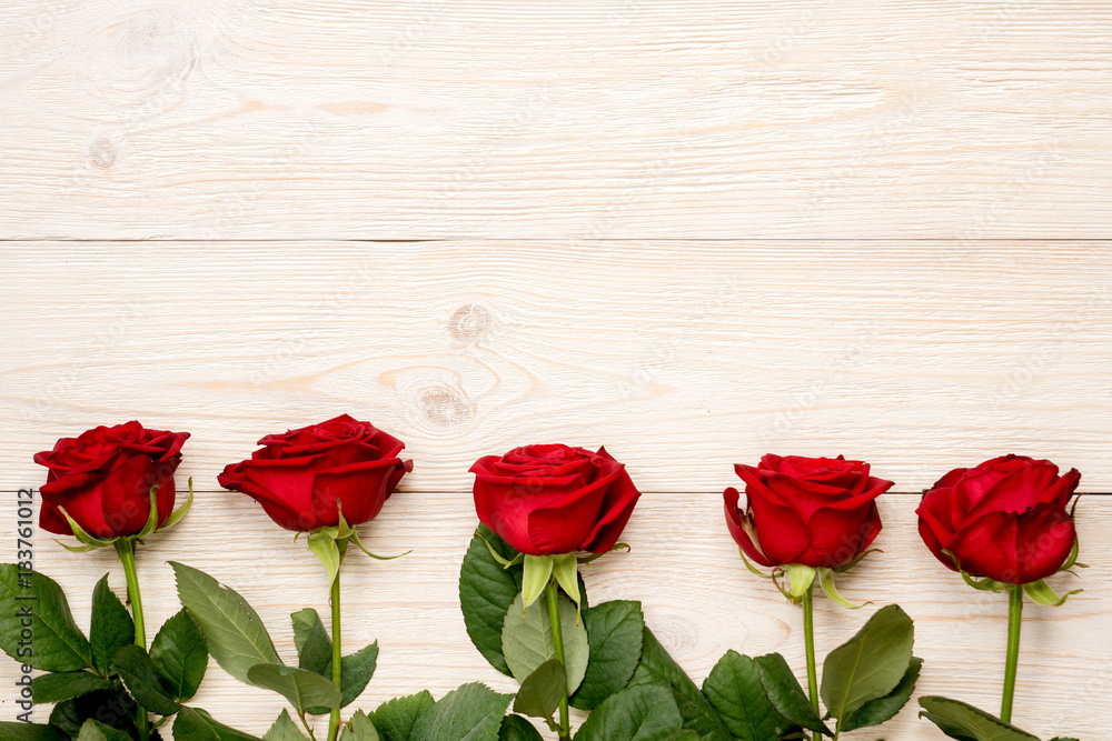 5 red roses in row on white rustic desks Stock Photo | Adobe Stock