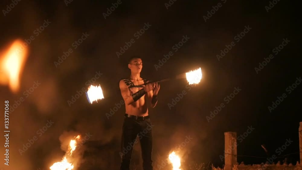 Fire show performance. Three handsome male fire performers dance ...