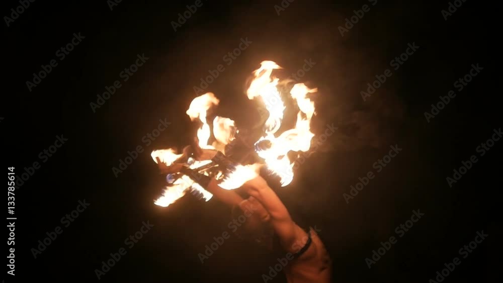 Fire show. Handsome male fire performer twirling fire baton with ...