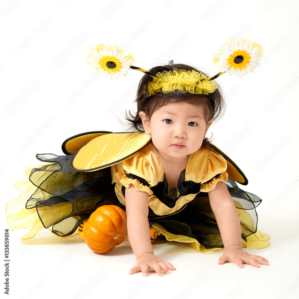 Baby girl dressed as cute little bee with a small pumpkin smiling Stock ...