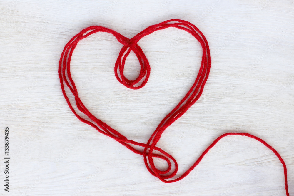 festive Valentine/ heart symbol of the red threads lying on a light ...