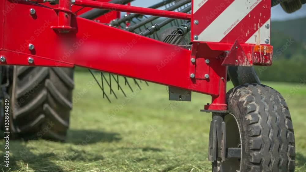Rotary hay rakes is moving fast when a farmer is working out in the ...
