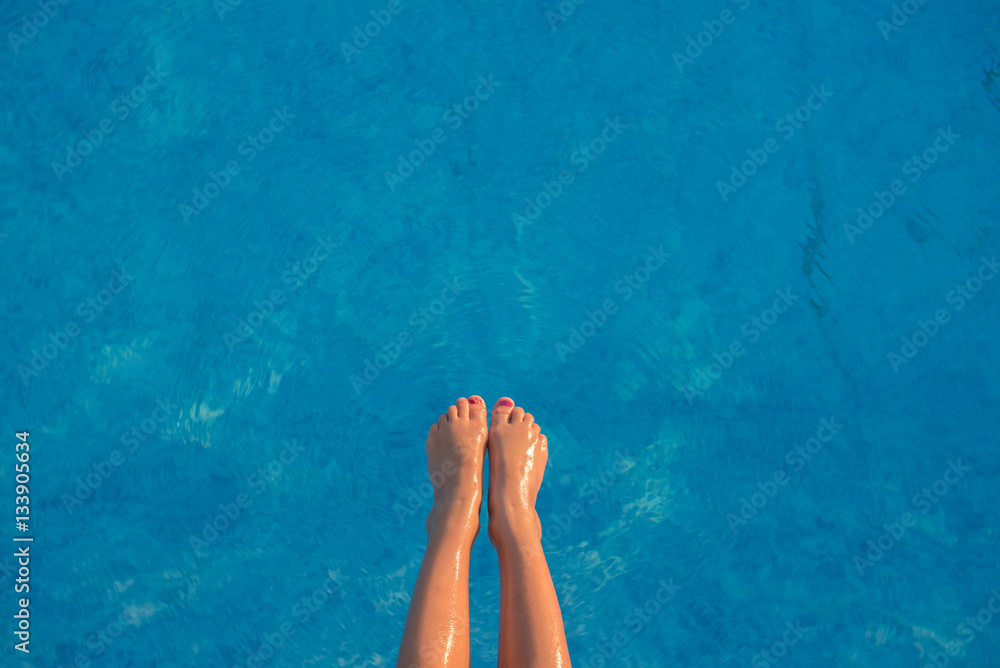 Young girl floating in swimming pool, focus on feet Stock Photo | Adobe ...
