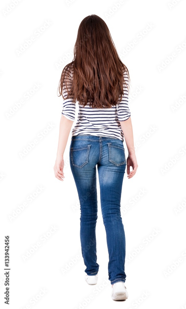 back view of walking woman in jeans . Stock Photo | Adobe Stock