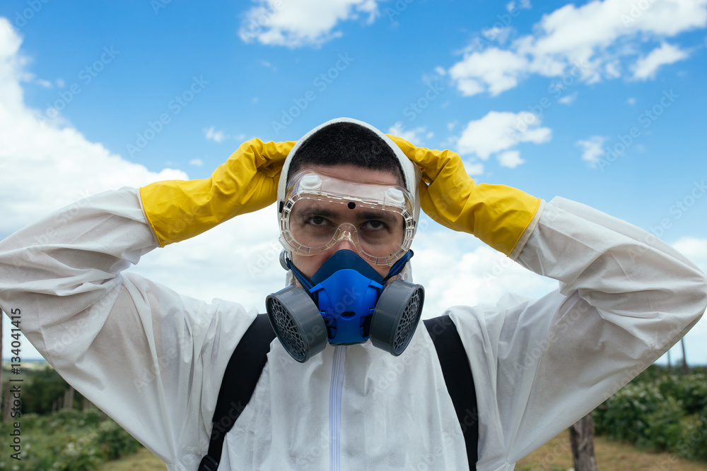 Industrial agriculture theme. Portrait of worker putting on protective ...