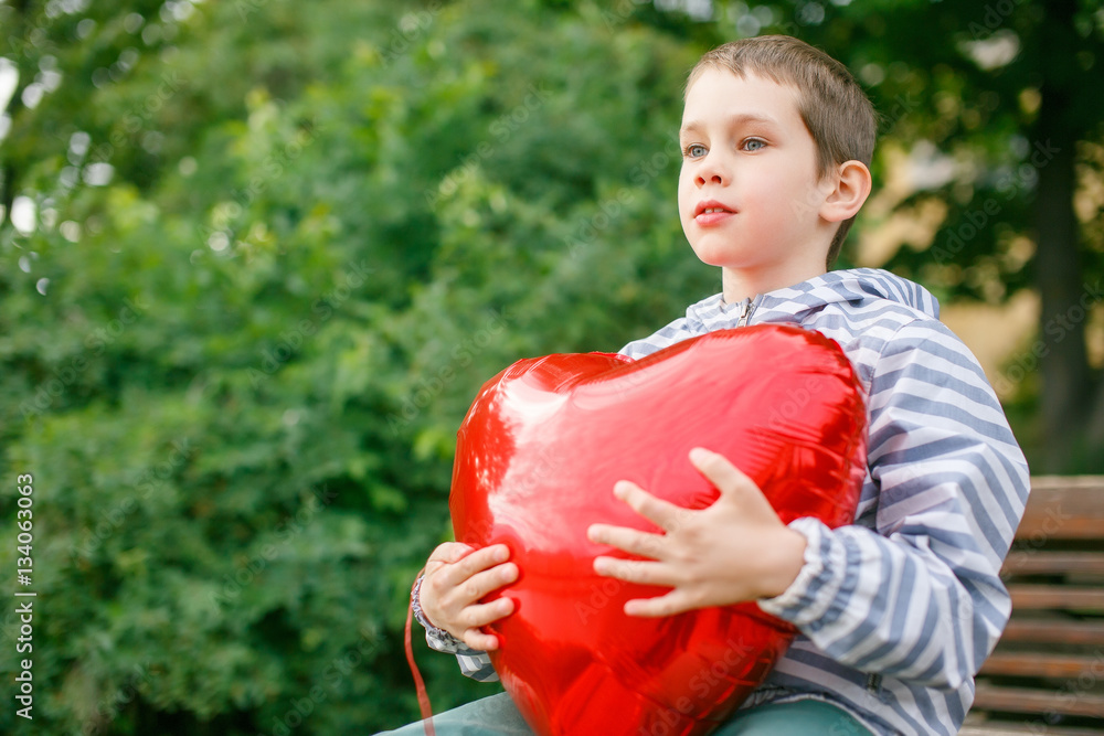 boy hugging a big red heart balloon. Valentine's day. empty space for ...