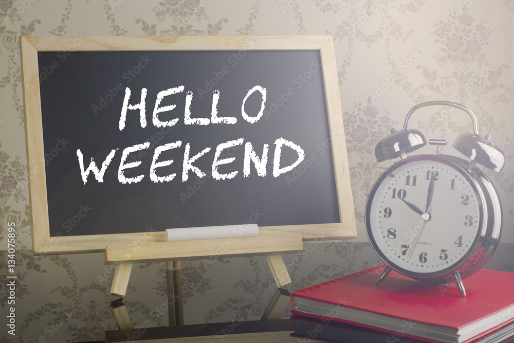 Hello Weekend on blackboard with flare and clock. Stock-Foto | Adobe Stock