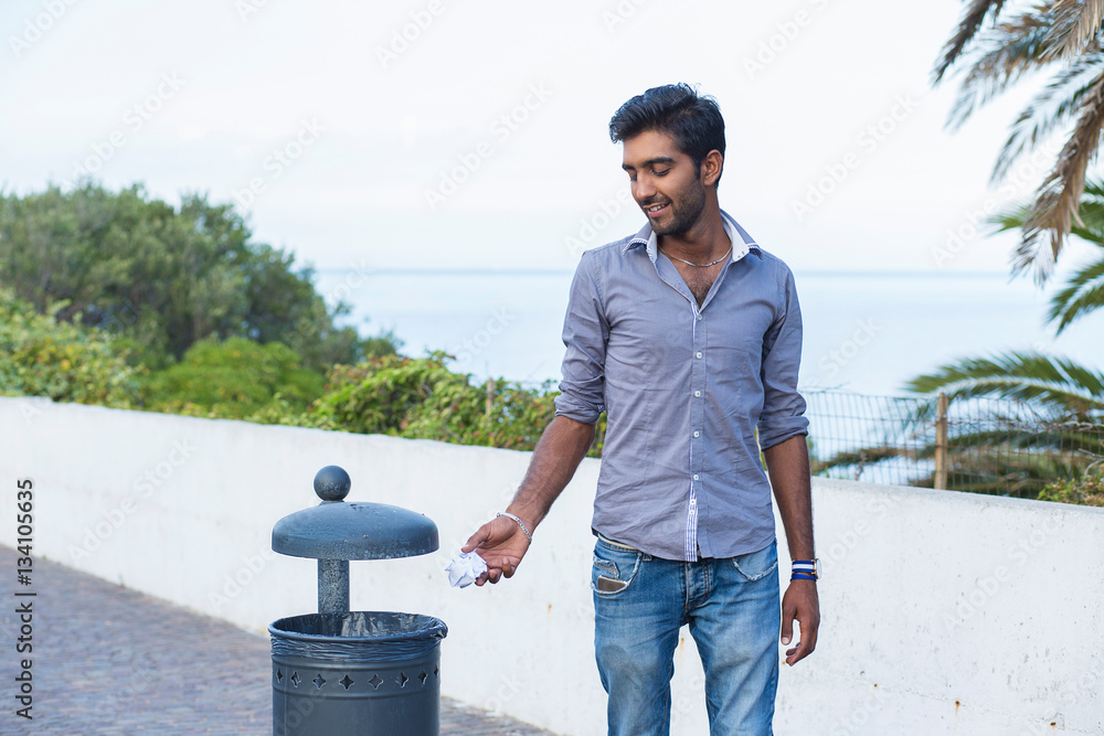 Man throwing trash in recycling bin, isolated outside seaside tropical ...