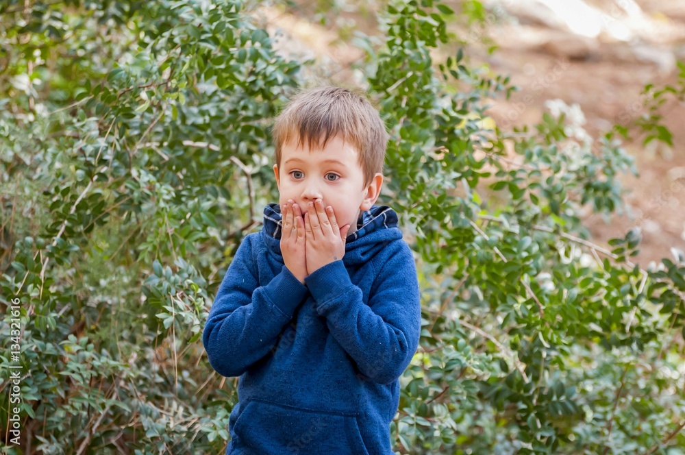 Foto de Little scared Caucasian boy closing his mouth with hands ...
