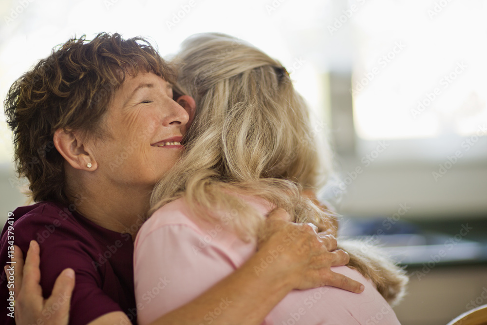 Smiling nurse hugging a relieved patient. Stock Photo | Adobe Stock