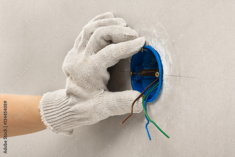 hand of electrician in glove installing plastic outlet box foto de ...